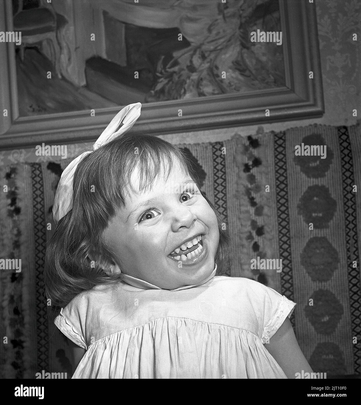 Girl in the 1950s. A charming and laughing girl is looking at the ...