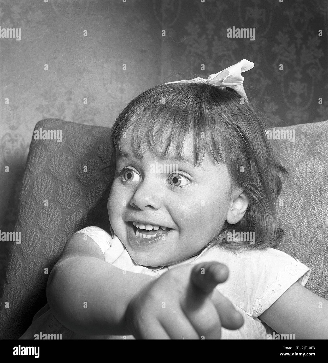 Girl in the 1950s. A charming and laughing girl is pointing at the ...