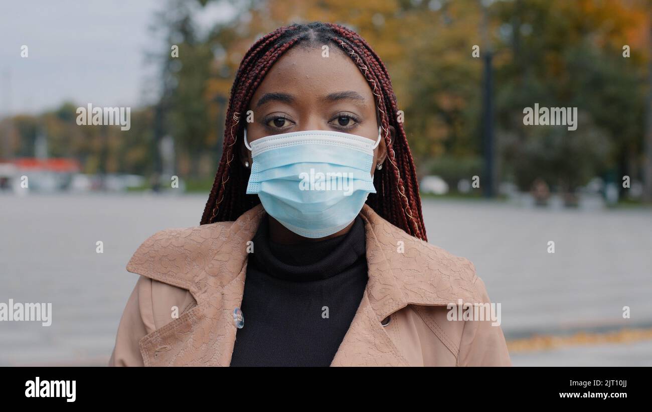 Close-up young serious stylish african american woman standing outdoor ...