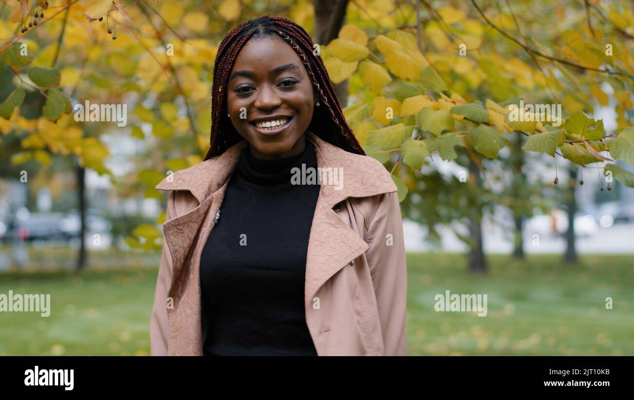 Young Positive Happy African Woman Standing In Autumn Park Looking At