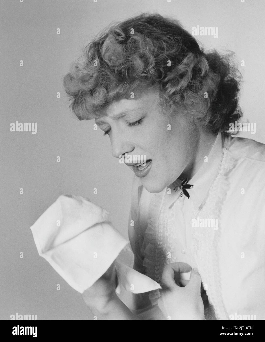 In the 1950s. A young woman has a cold and sneezes in a tissue paper ...