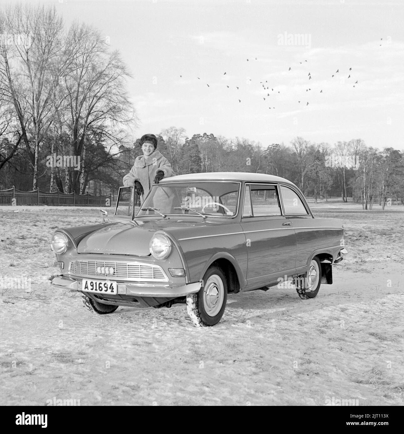 In the 1960s. A young woman in the winter with her brand new car, a DKW ...