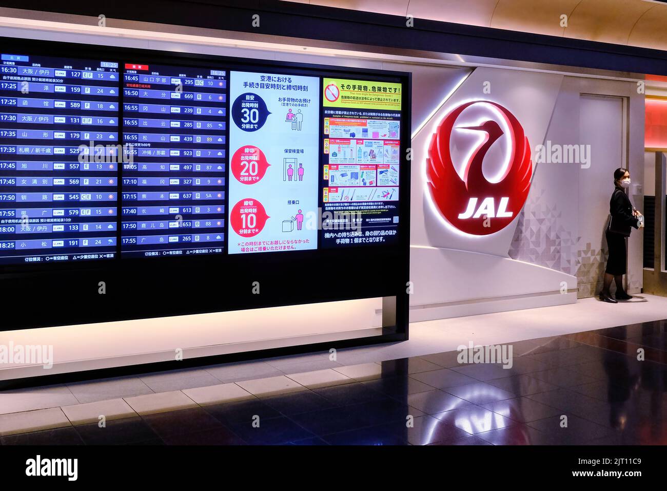 An employee of Japan Airlines (JAL) wearing a face mask as a preventive ...