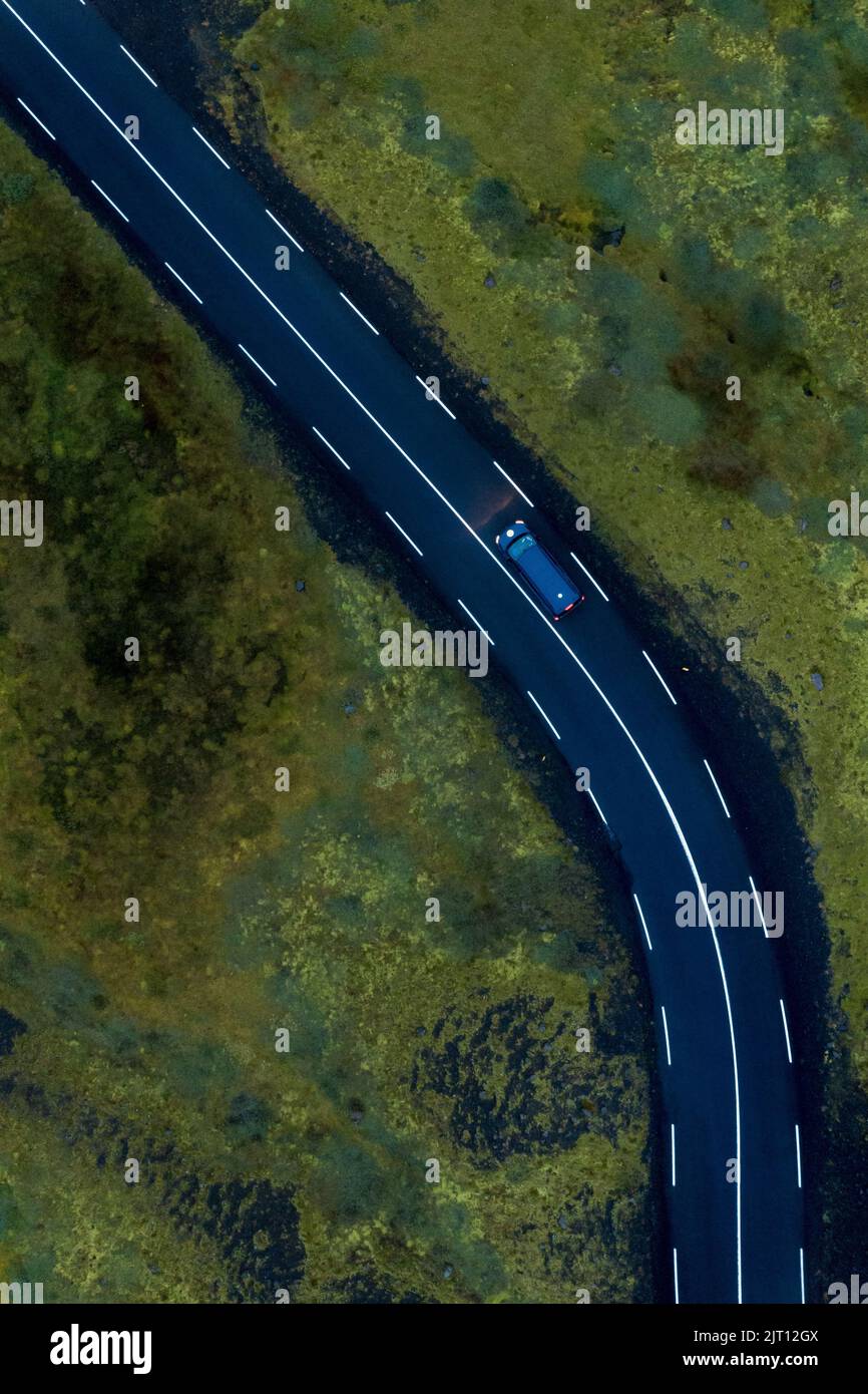 The driving on a road through the green mossy river water in Iceland ...