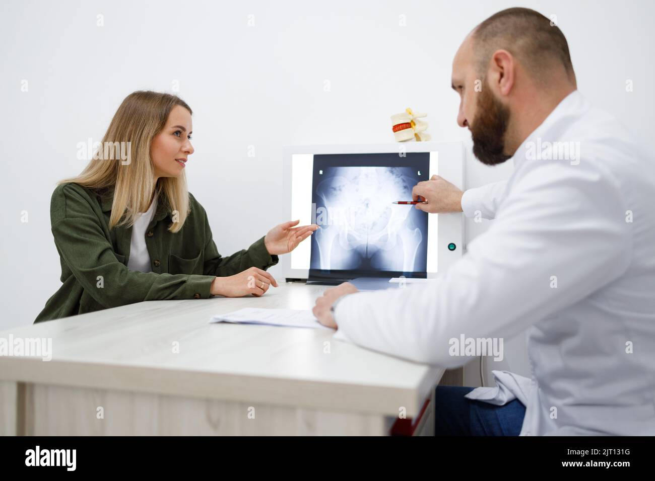 Orthopedist showing x-ray image to female patient. Woman during a ...