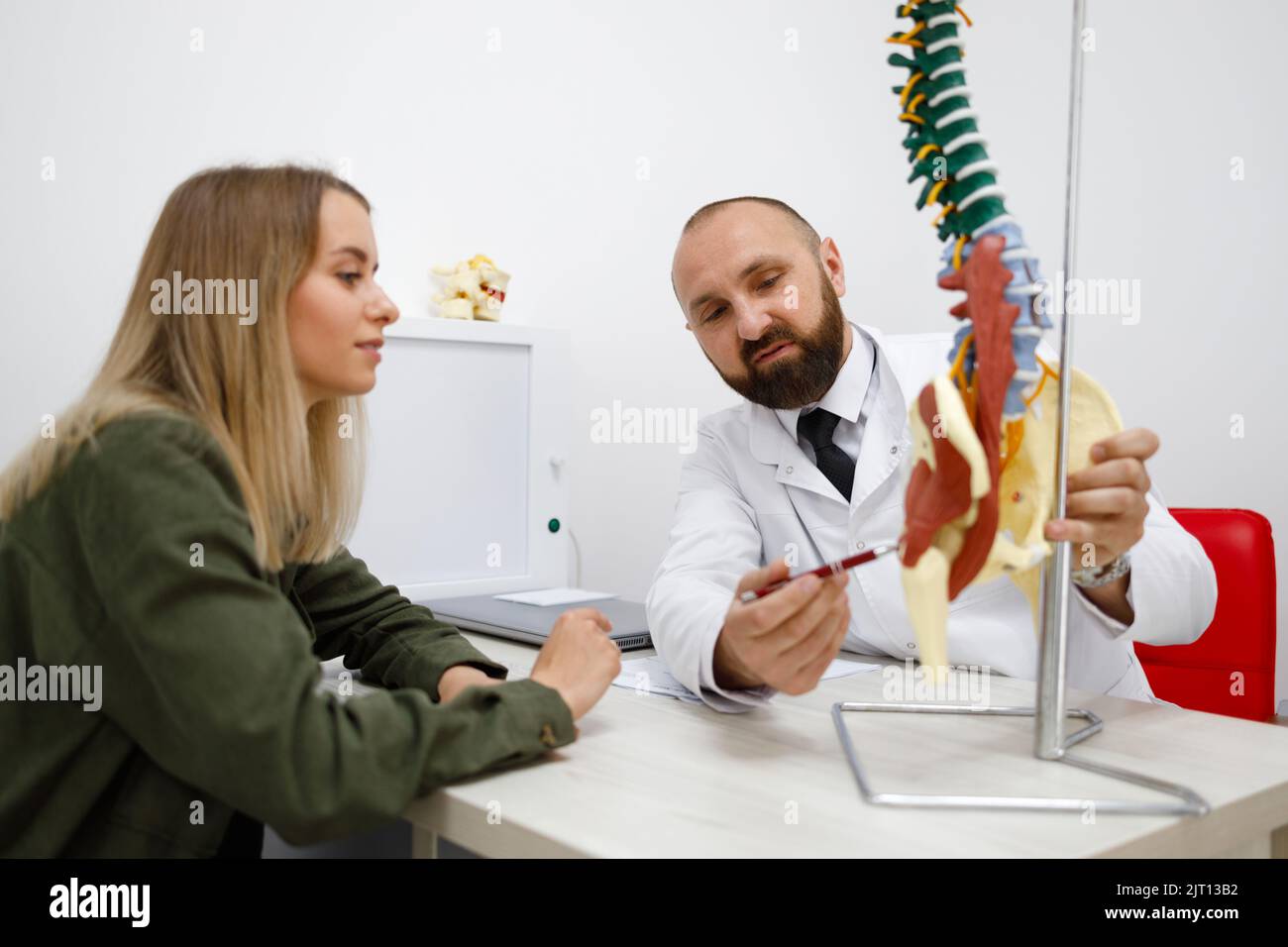 Doctor showing spine model to patient Stock Photo - Alamy