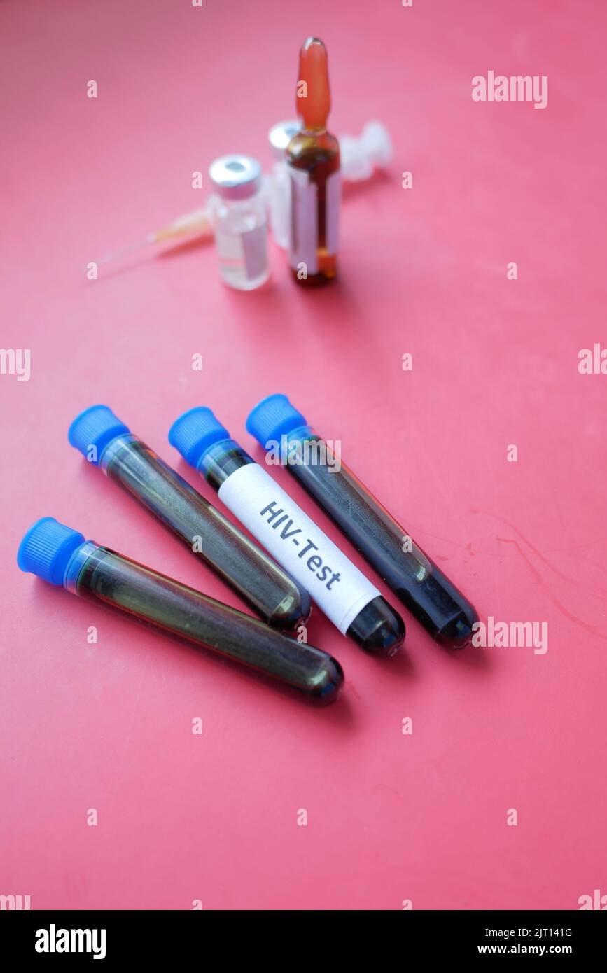 HIV blood test tube and syringe on red background Stock Photo - Alamy