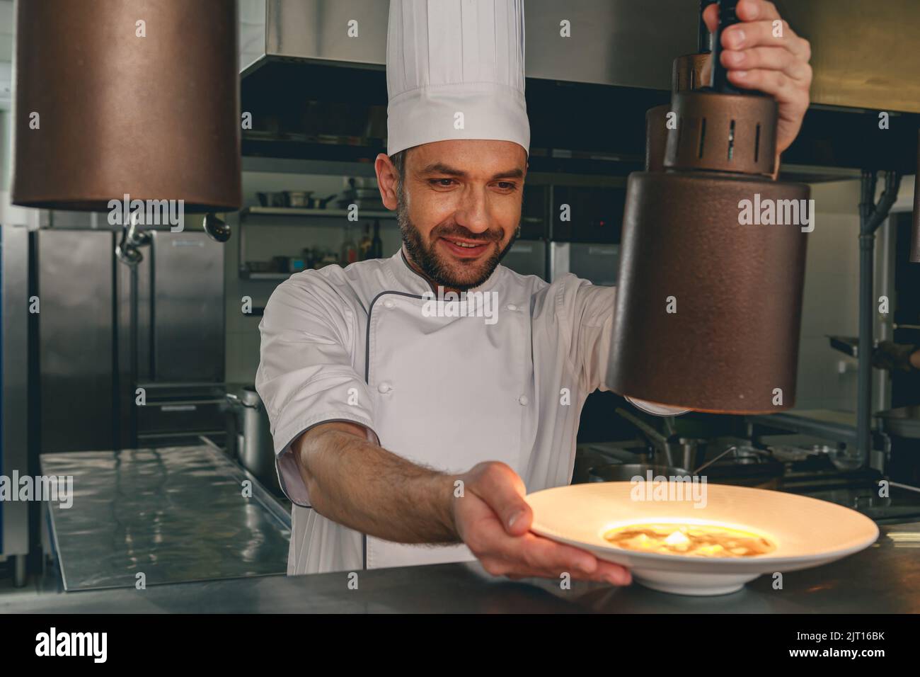 Professional chef checks dish just before serving it to customer in ...