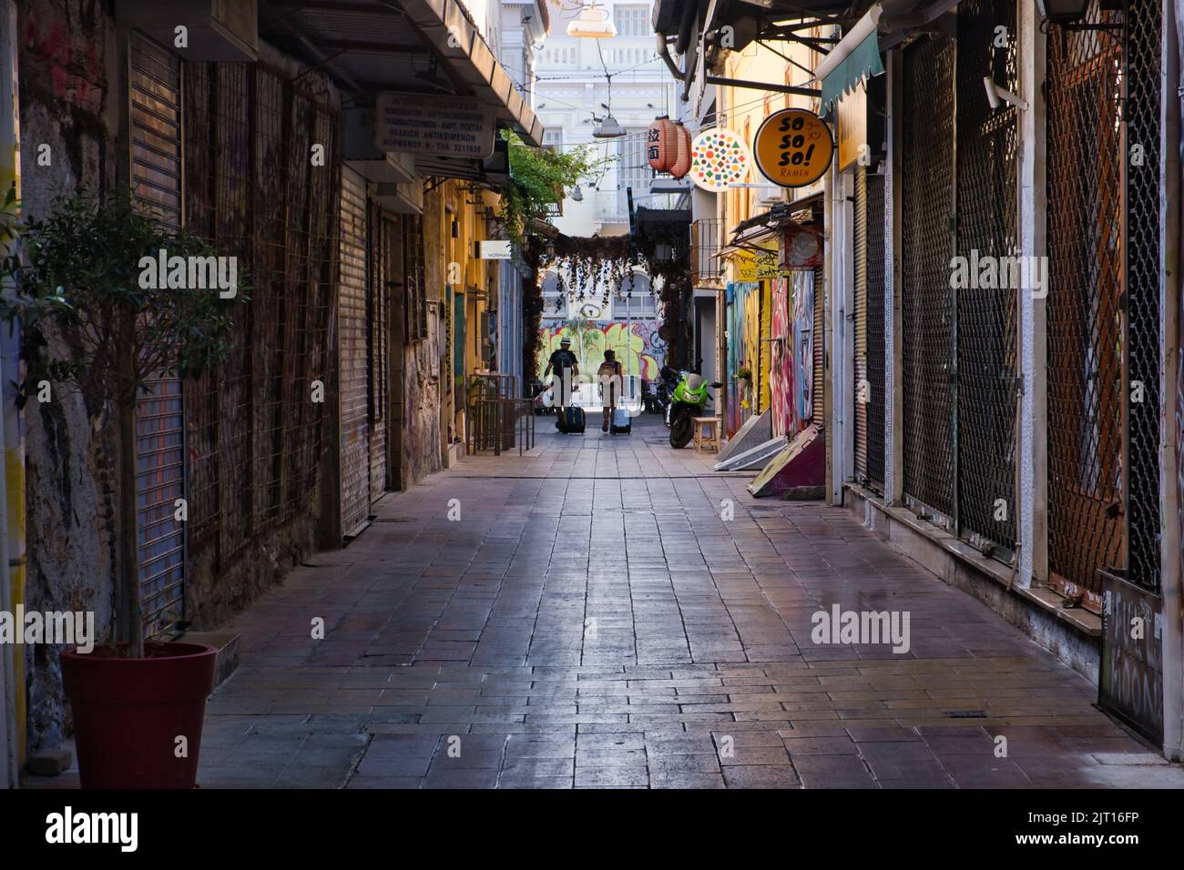 Tourists with luggages in an alley in Monastiraki district in Athens ...