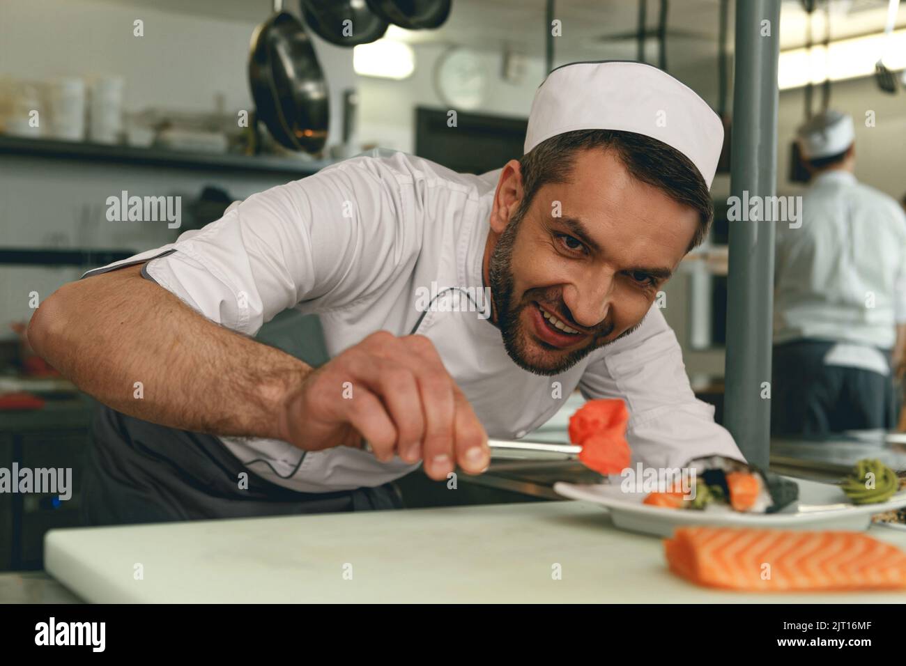 Sushi master prepares sushi for serving in modern commercial kitchen ...