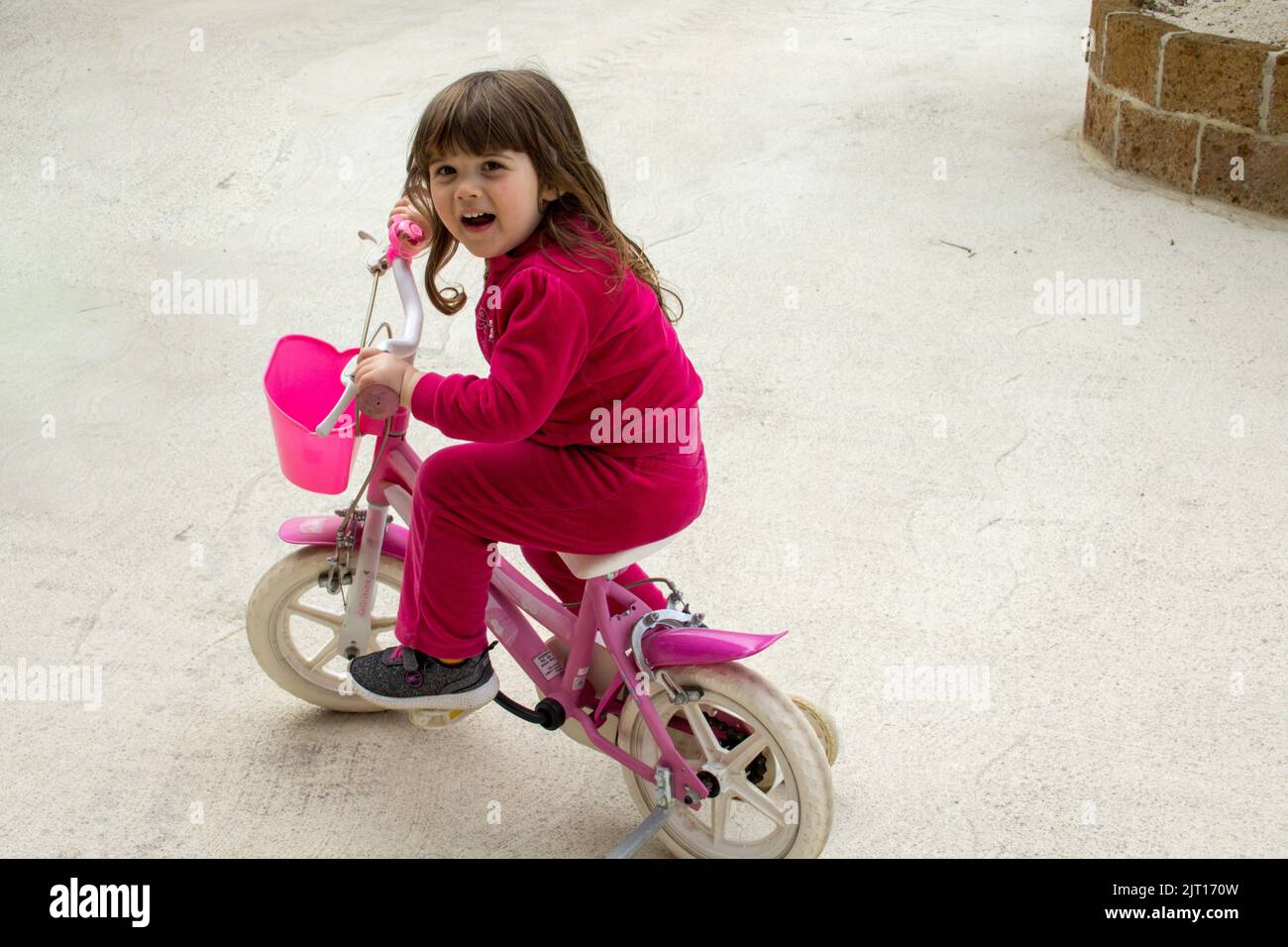 Image of an adorable smiling little girl learning to ride a bike with ...