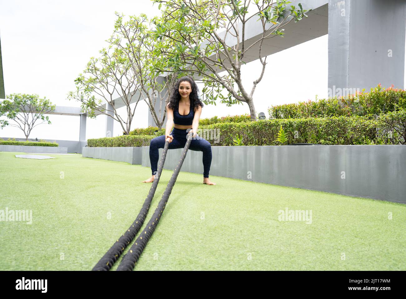 Woman doing Battle rope workout on roof top Condominium Stock Photo - Alamy