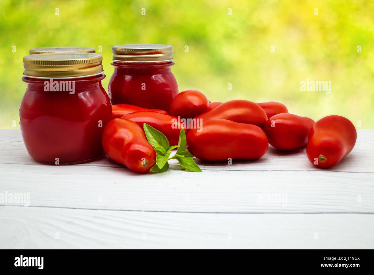 Traditional Italian tomato sauce in a glass jar with fresh tomatoes and ...