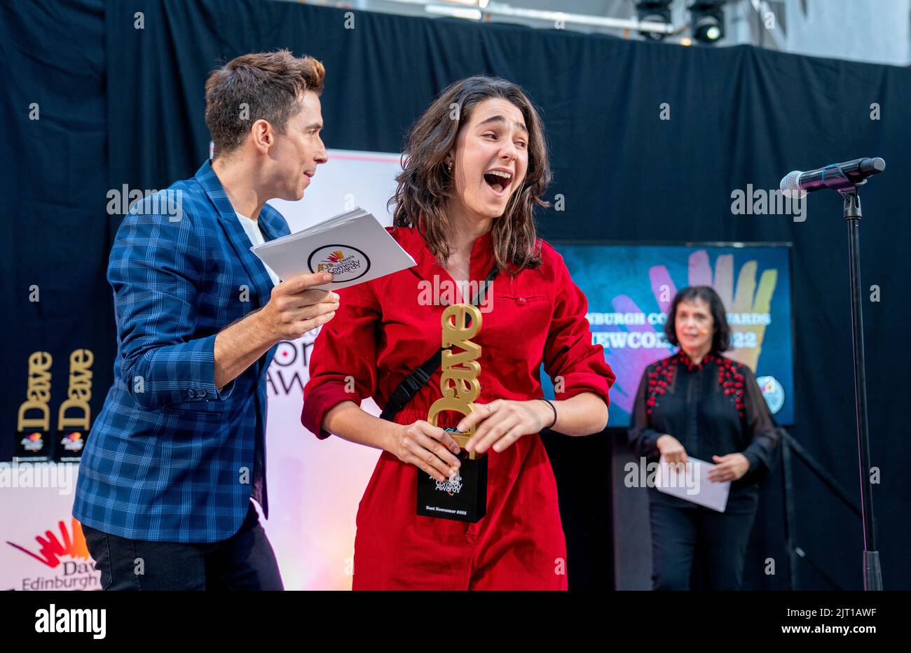 Lara Ricote, with Russell Kane (left), reacts after winning the Dave's ...