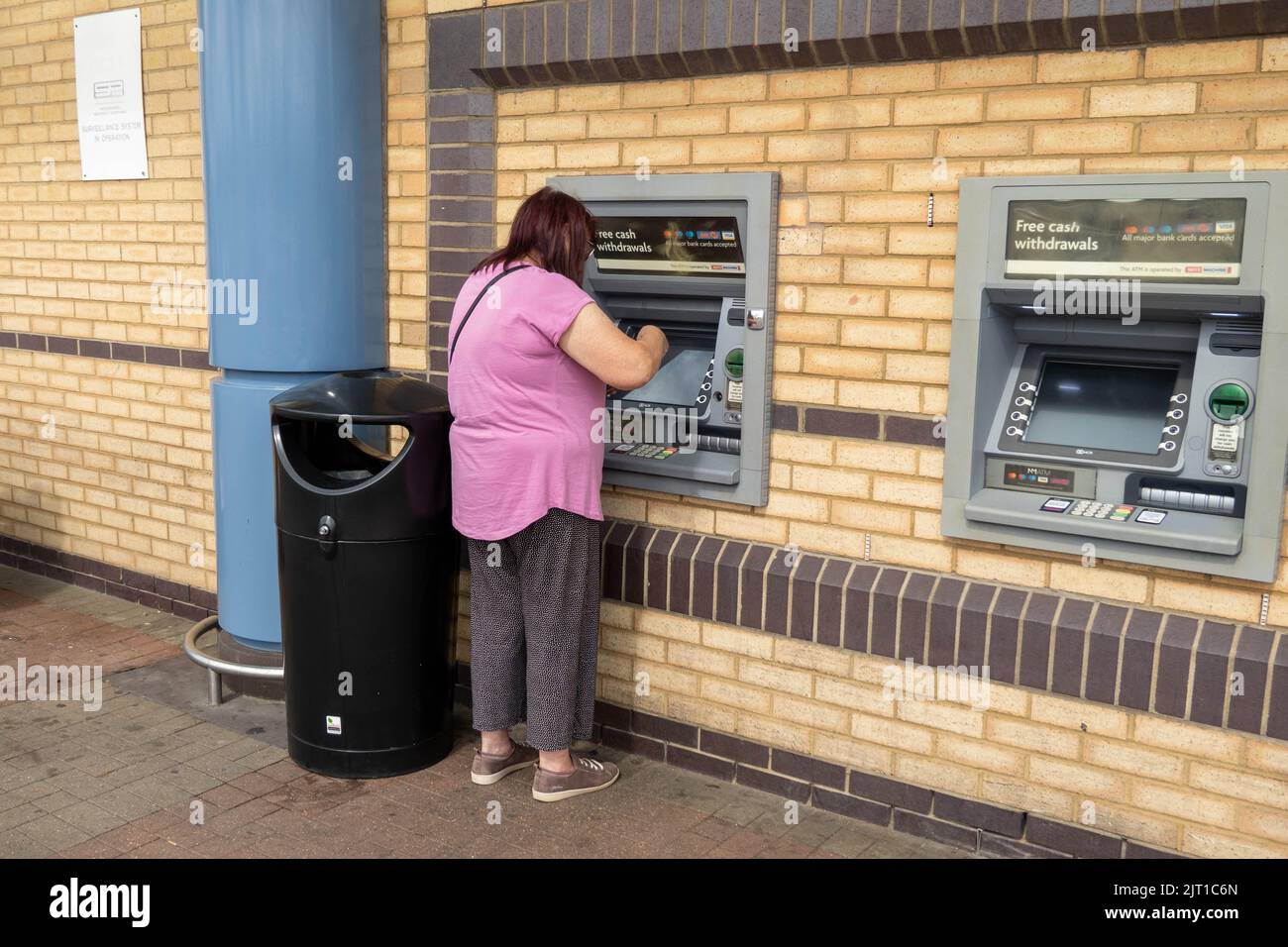 Lady woman using cashpoint at Morrisons supermarket in Riverside Retail ...