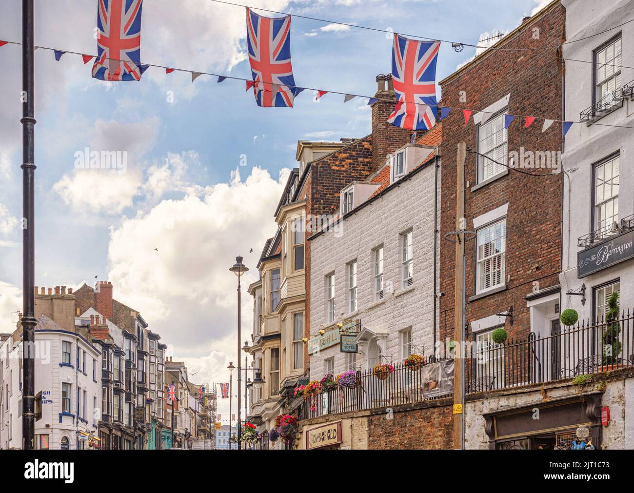 The upper level of a street of brick buildings. Union flags are hanging ...