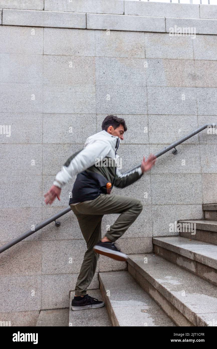 Caucasian man claiming stairs rapidly wearing a jacket Stock Photo - Alamy
