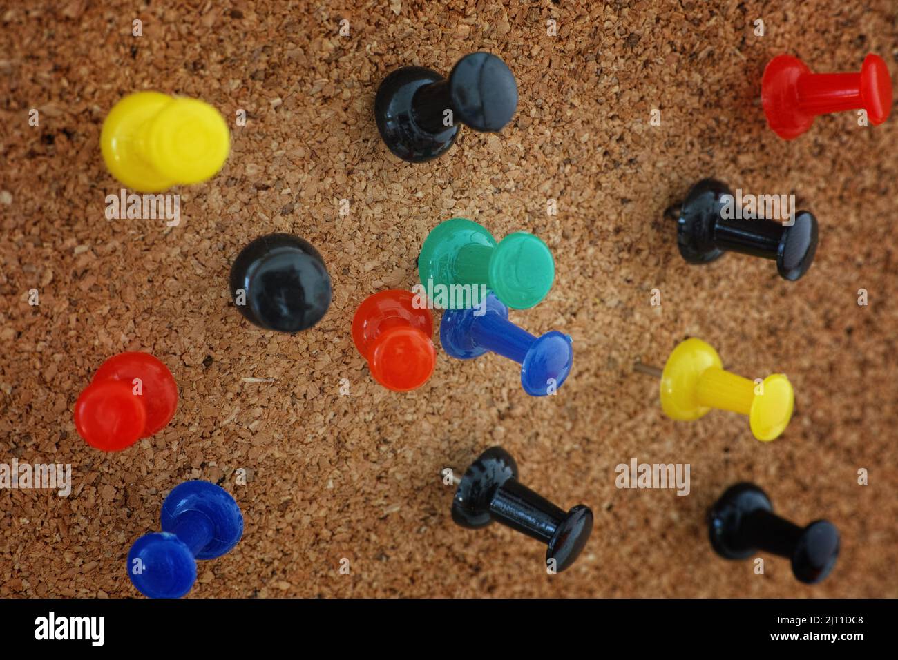 Colorful tacks attached to a corkboard. Close up Stock Photo - Alamy