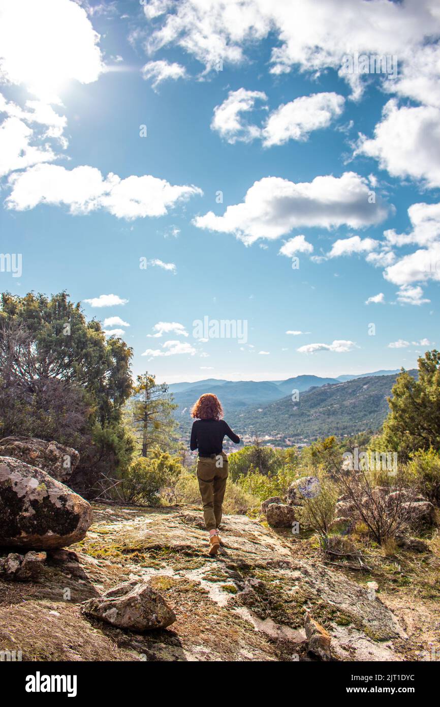 ginger photographer walking in nature. She es wearing hiking clothing ...