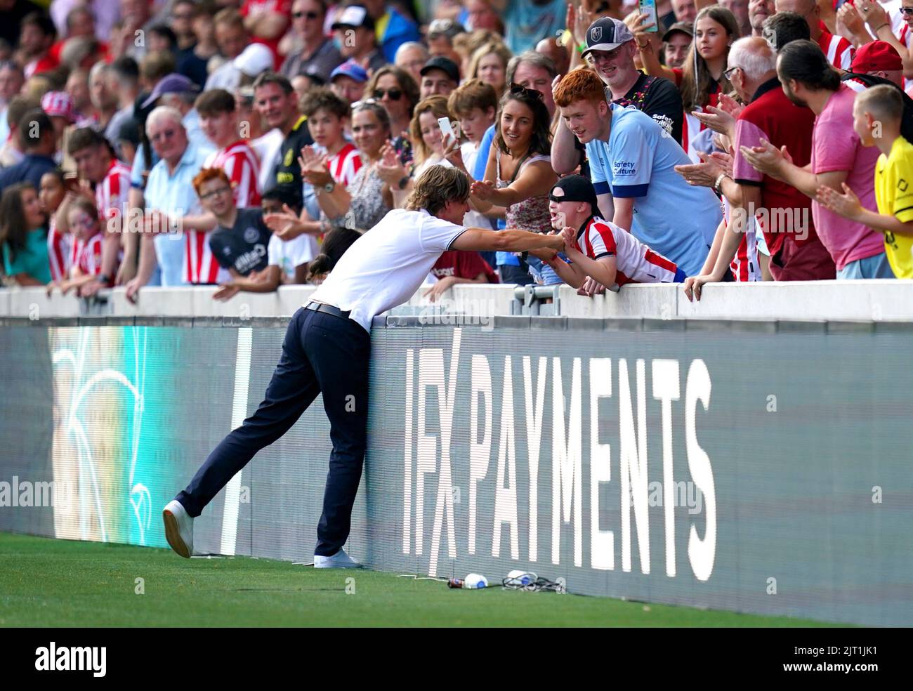 Brentford manager Thomas Frank interacts with a fan at the end of the ...