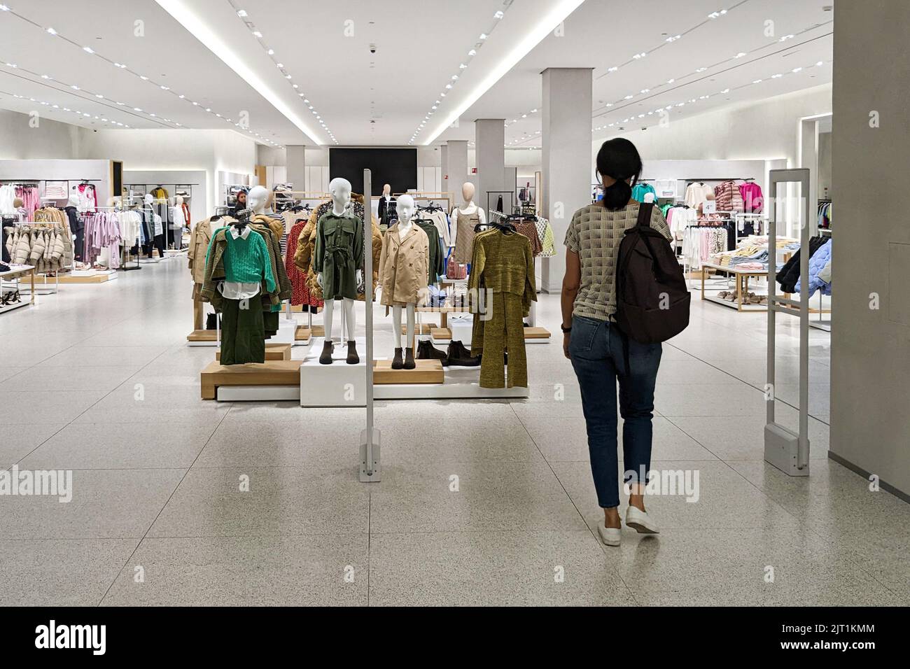 Middle age woman entering children clothing store in shopping center ...