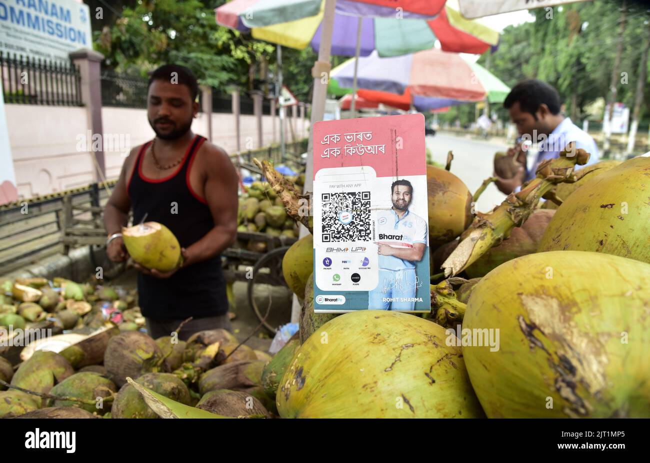 Guwahati, Guwahati, India. 27th Aug, 2022. A coconut vendor puts ...