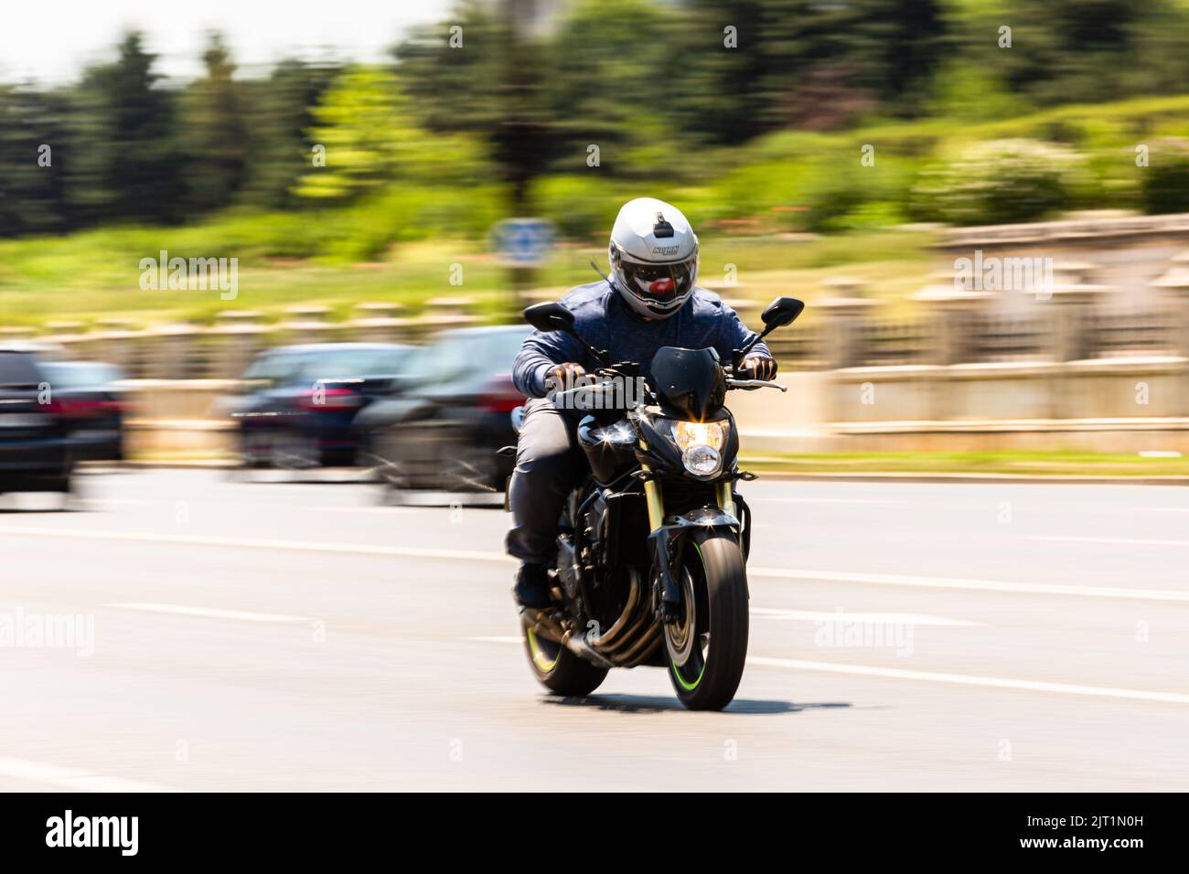 Biker on a motorcycle in traffic at rush hour in downtown area of the ...