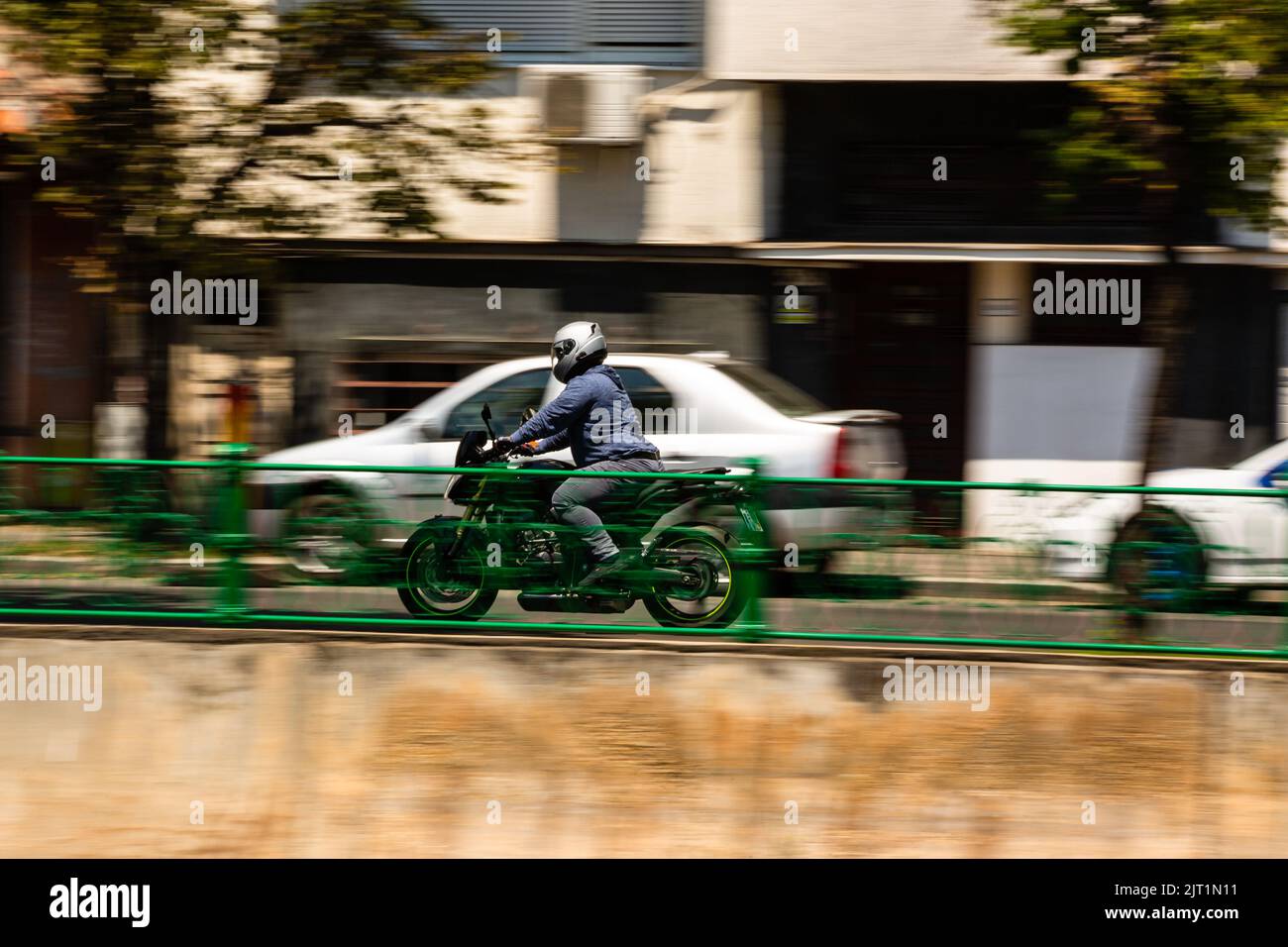 Biker on a motorcycle in traffic at rush hour in downtown area of the ...