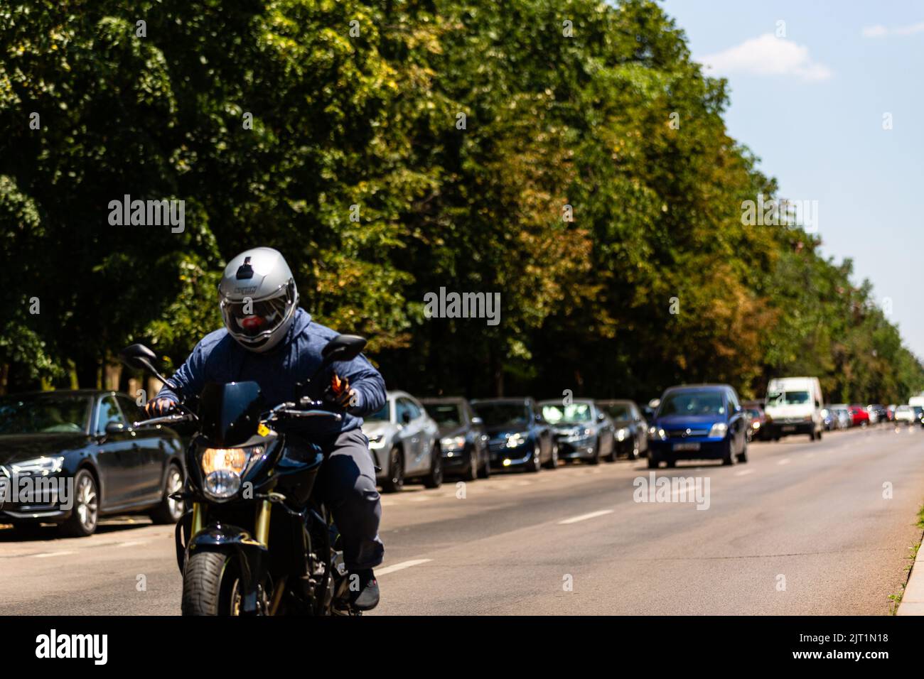 Biker on a motorcycle in traffic at rush hour in downtown area of the ...