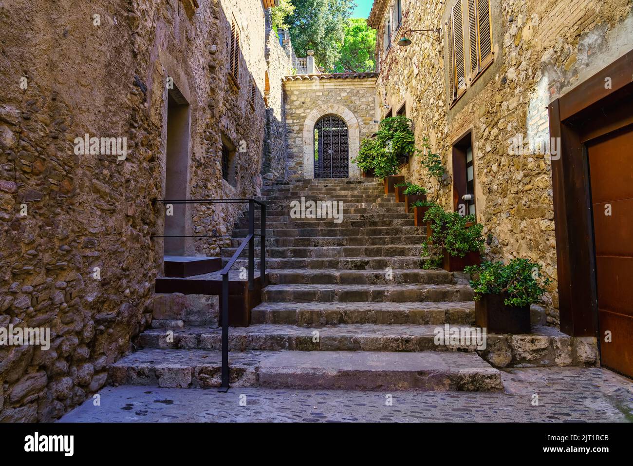 Narrow alley with stairs in the medieval town of Besalu on the Costa ...