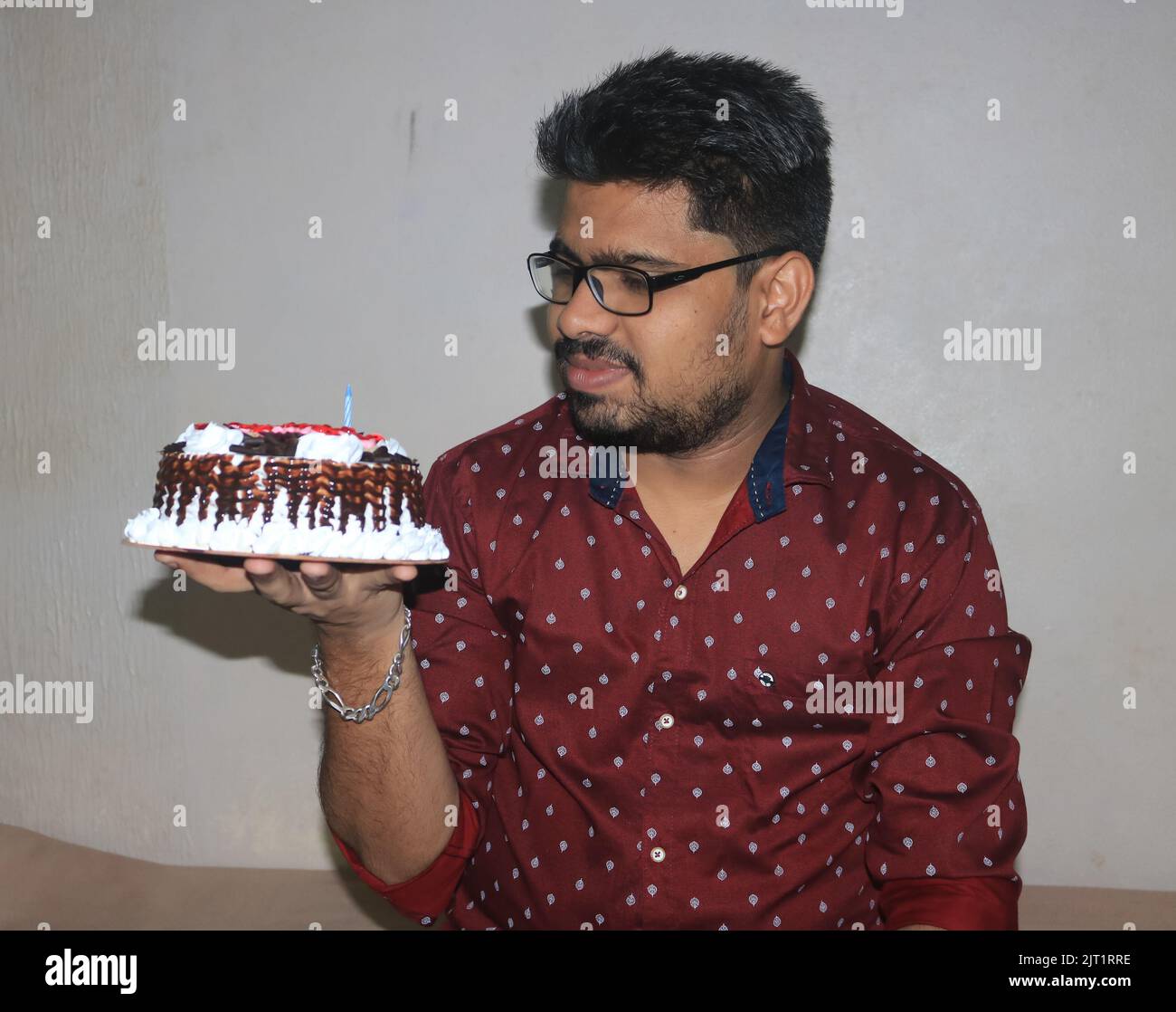 An Indian male holding a Birthday cake Stock Photo - Alamy