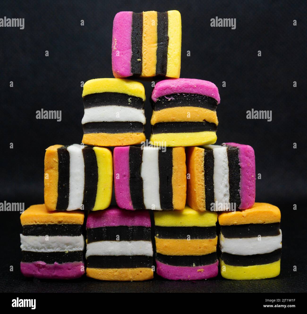 A four tiered pyramid of colorful licorice candy isolated on black ...