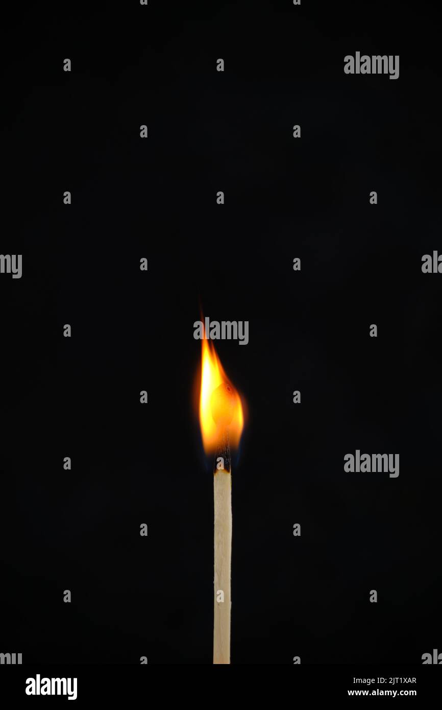 Standing, burning match on a black background Stock Photo - Alamy