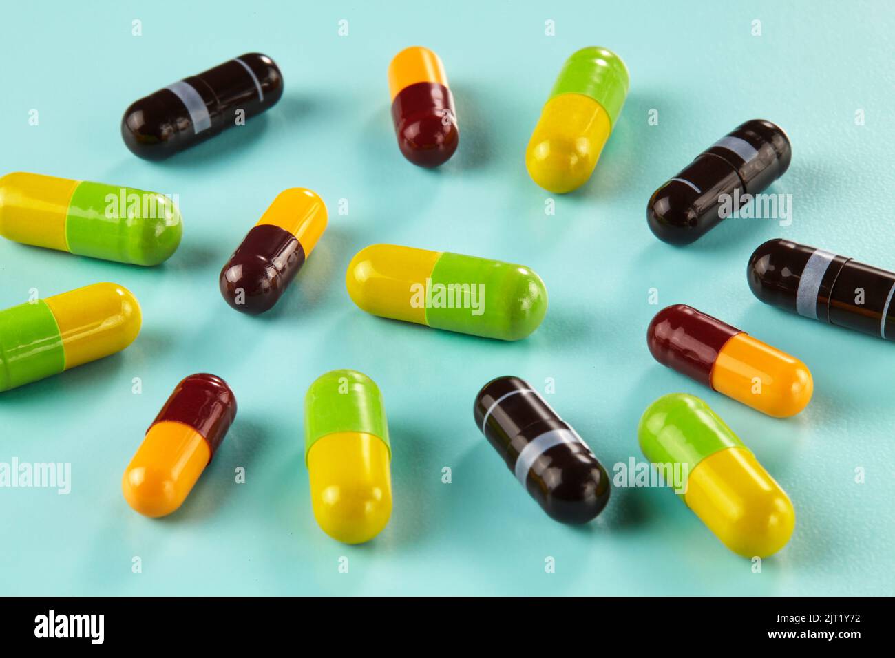 Capsules of three kinds are scattered on a cyan background Stock Photo ...