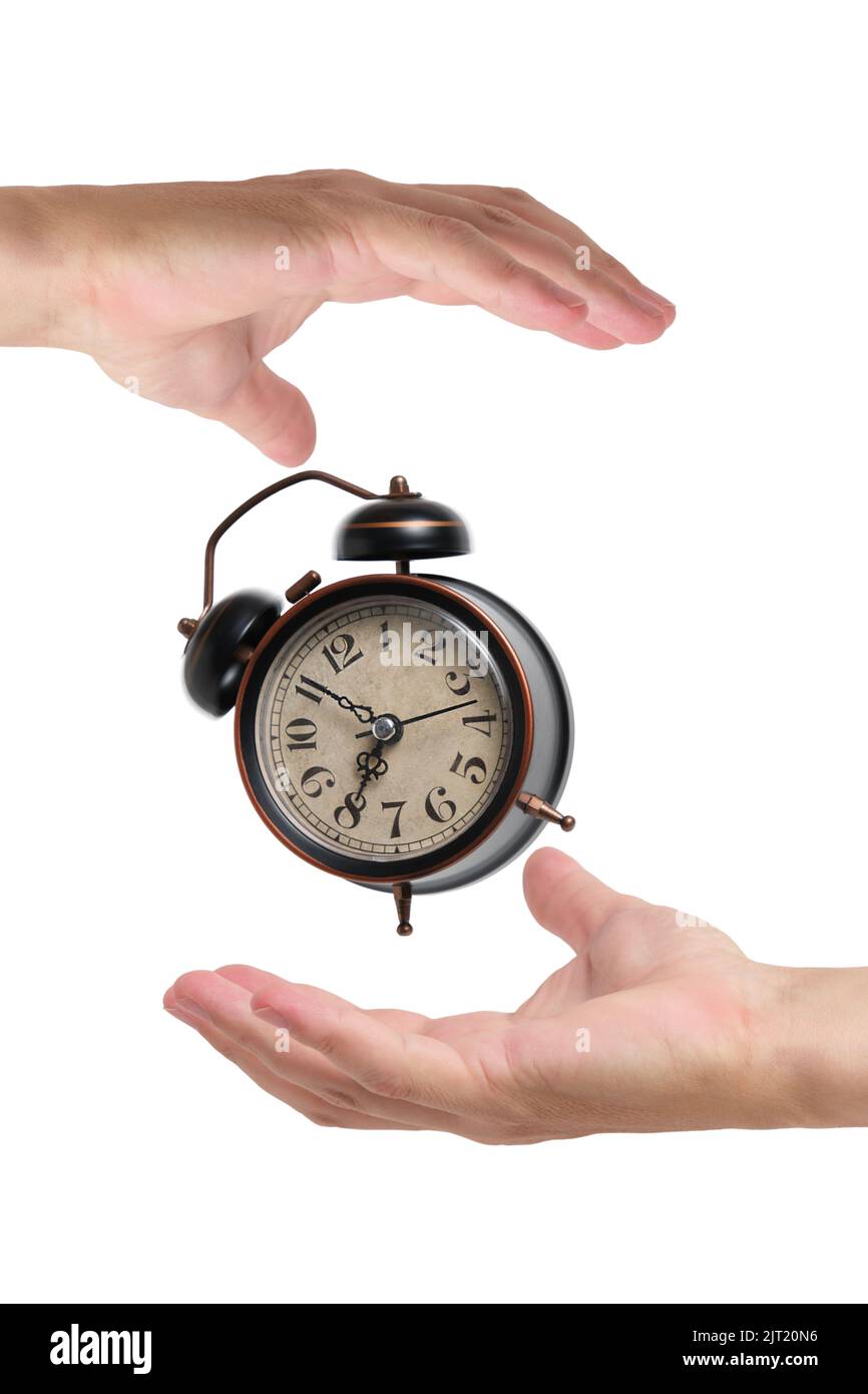 Ringing and hovering old retro alarm clock above hand on white ...