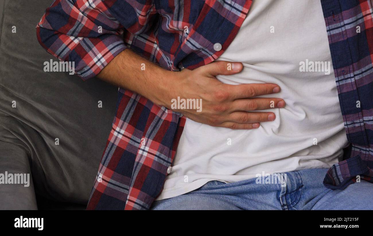 Pain in the side. Man suffers from liver pain Stock Photo - Alamy