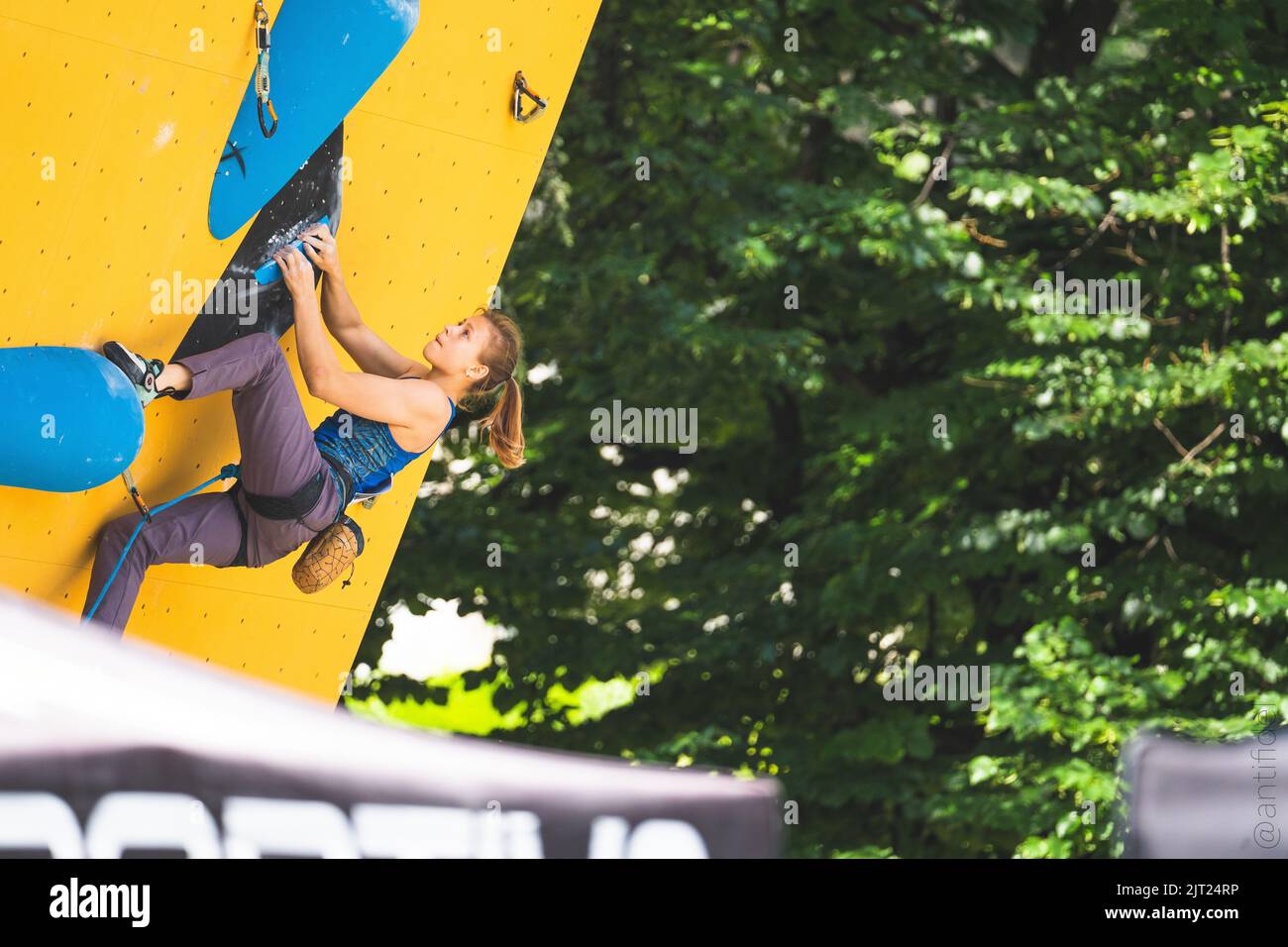 A young pretty Ukrainian lady athlete climber climbing on the yellow ...
