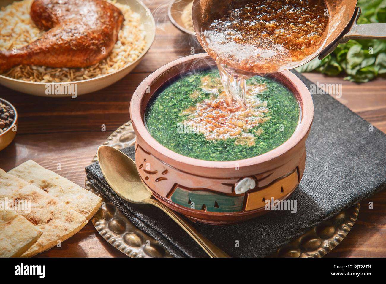 Arabic cuisine: Pouring fried golden garlic over a delicious stewed ...