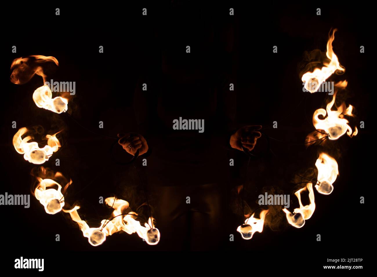 Fireshow in dark. Two steel fans with hot flames. Burning kerosene ...