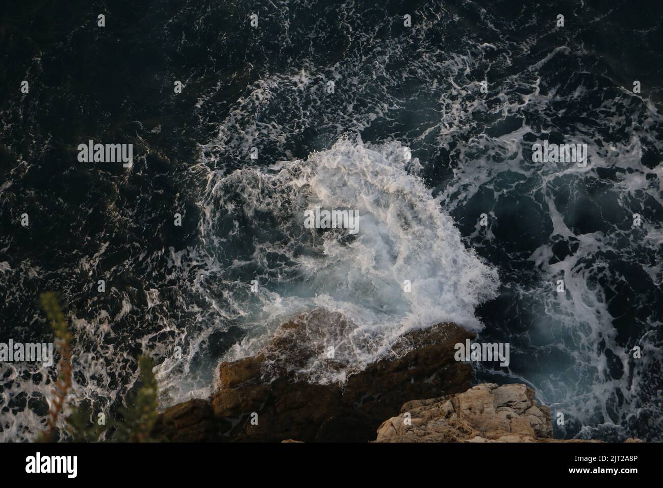 A beautiful shot of waves crashing into a rock and creating a big ...