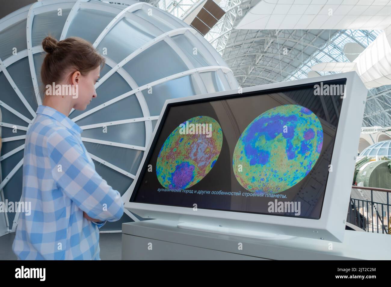 Woman looking at interactive touchscreen display kiosk at exhibition ...