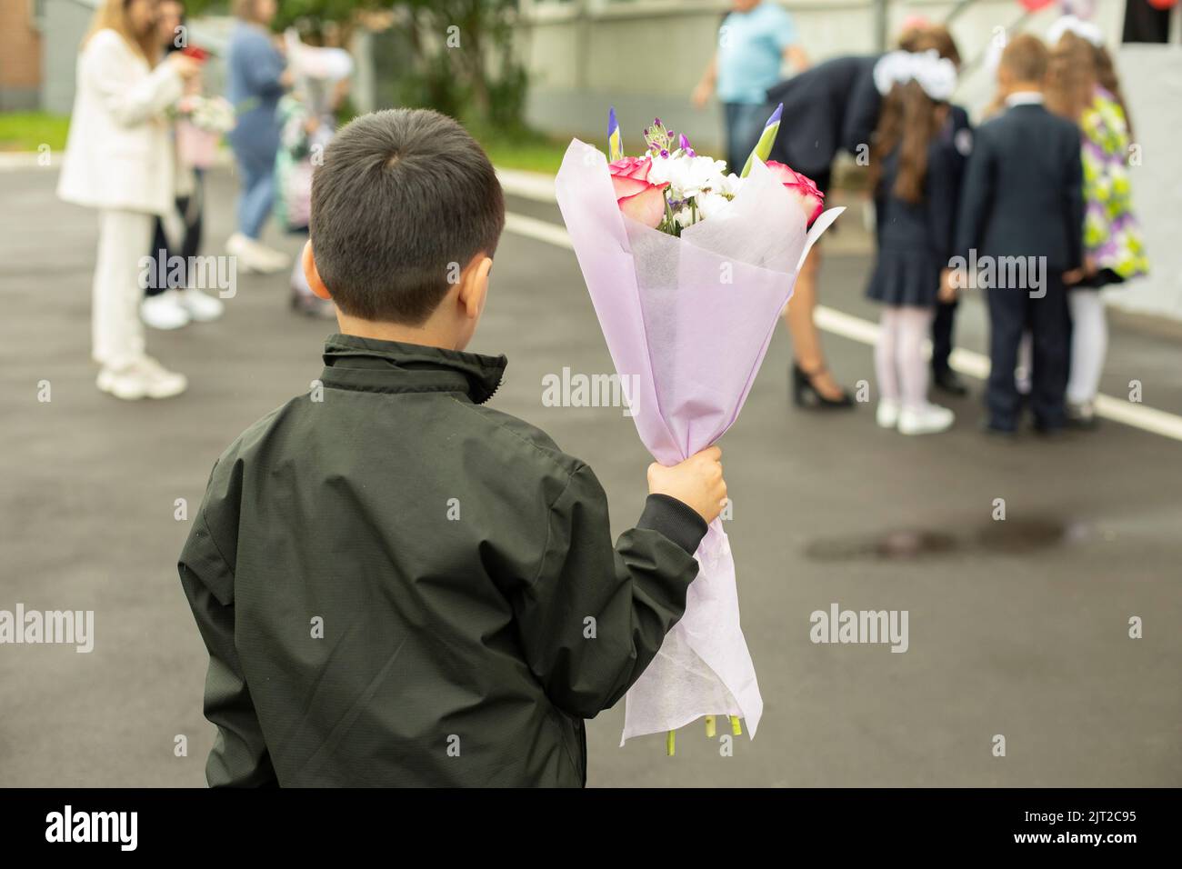 Child holds flowers. Schoolboy with bouquet for teacher. Boy at party ...