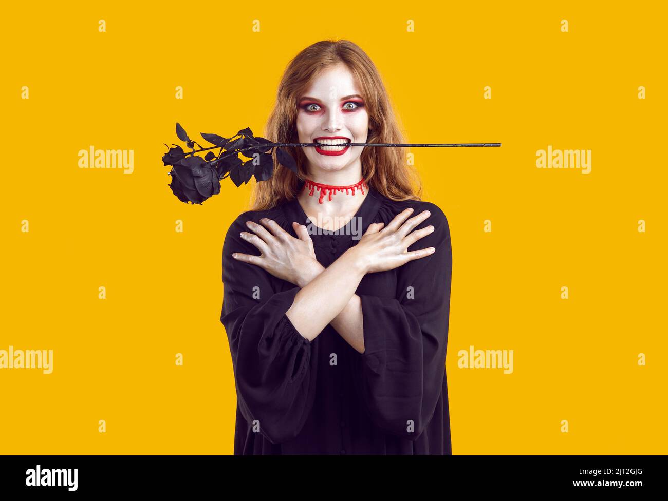 Smiling scary woman with black rose in her teeth in halloween costume ...