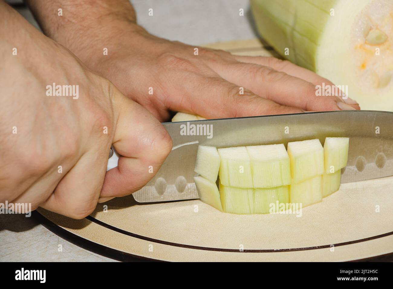 Recipe for zucchini fritters. Step 2 - cutting zucchini. Hands cut ...