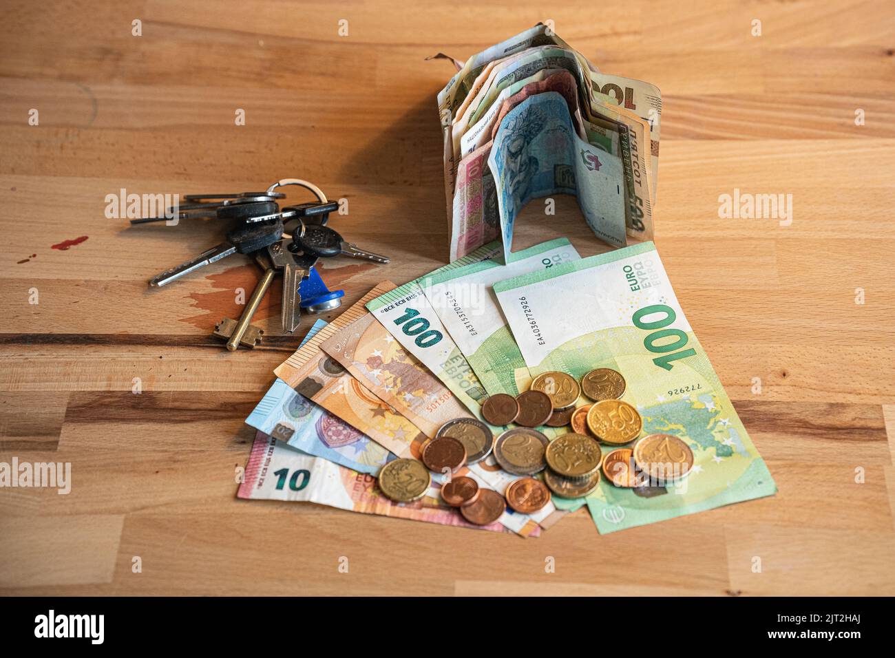 A collection of different types of currencies and keys placed on a ...