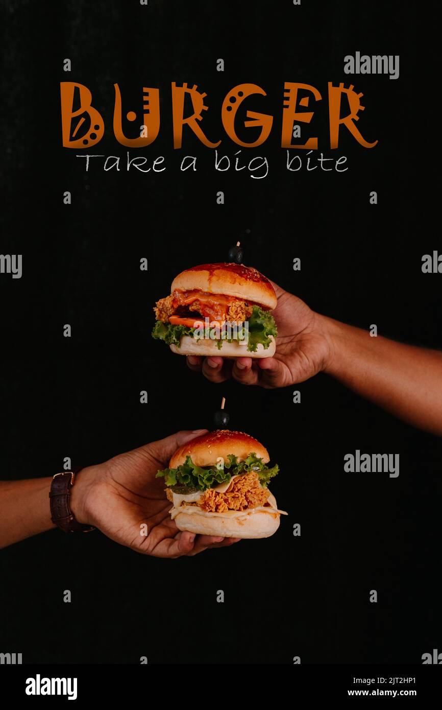 Holding burger two hands Stock Photo - Alamy