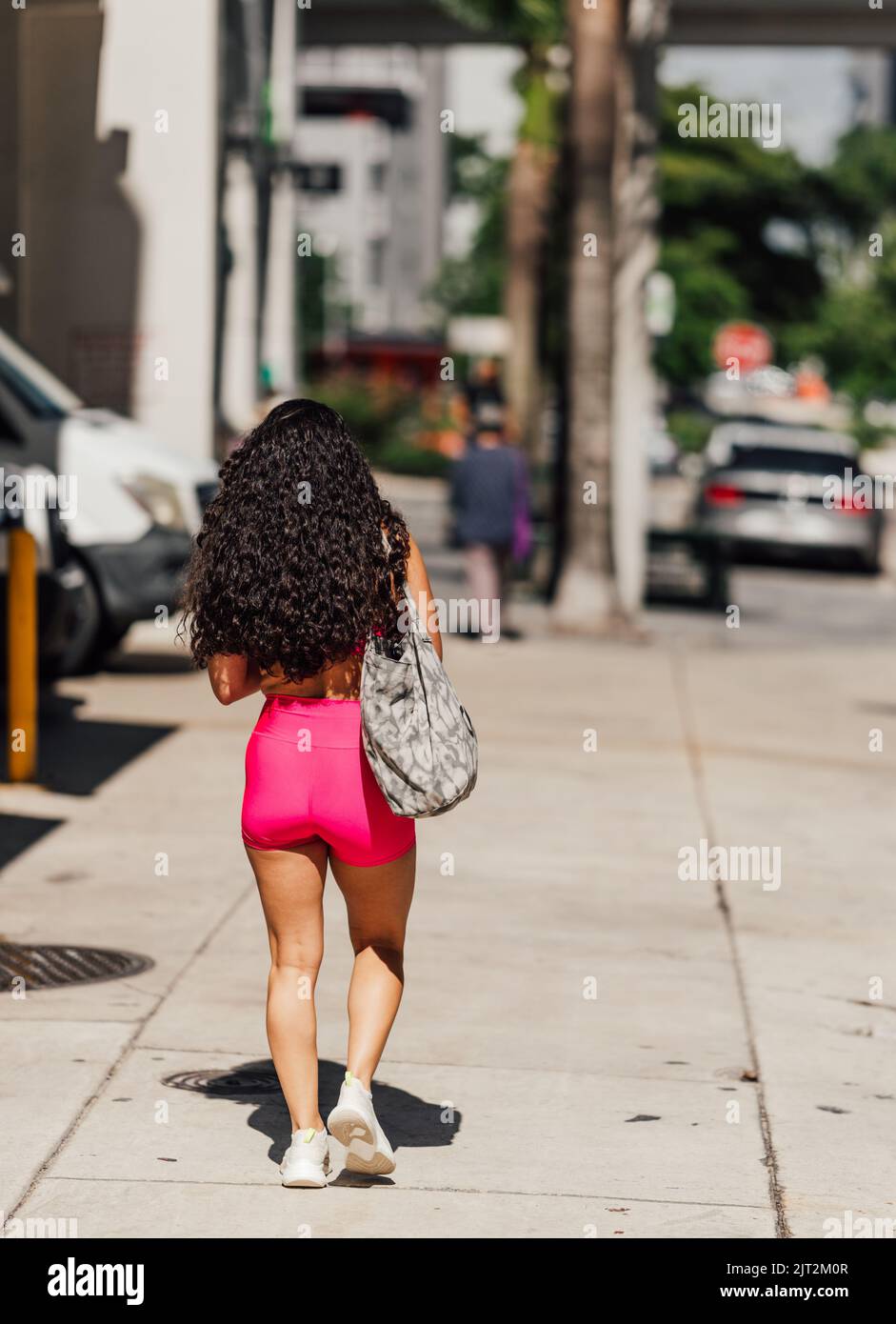 A back view of a fitness female walking on a street with a bag Stock ...