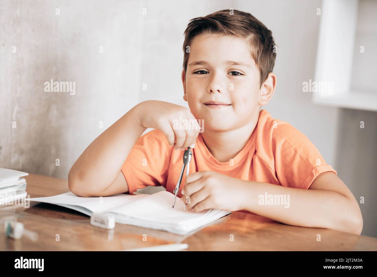 Little school boy doing homework with spring divider, sitting at the ...