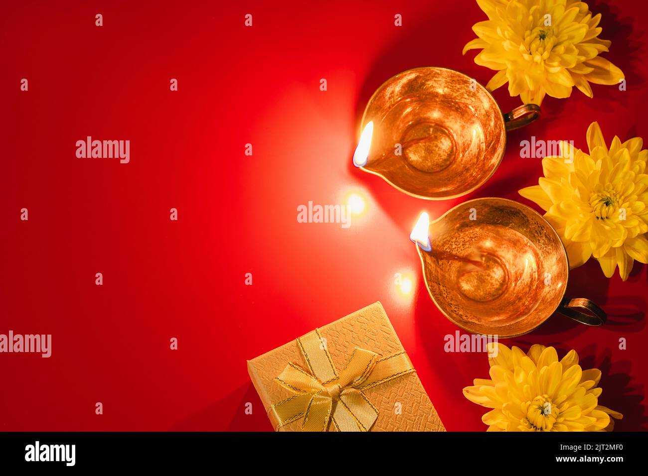 Happy Diwali. Diya oil lamp, flowers and gift boxes on red background ...