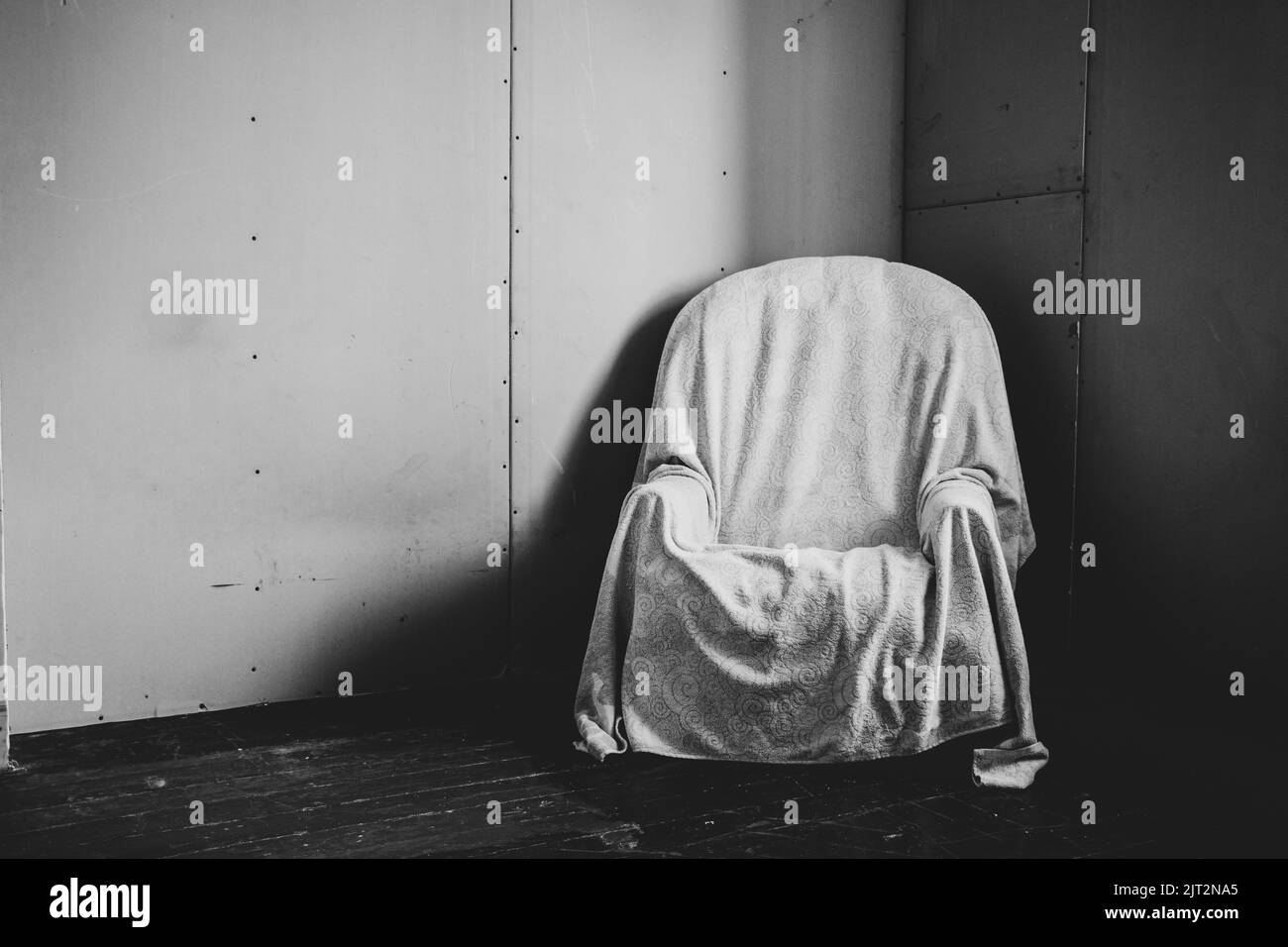 an old wooden flex chair stands in an empty room on the floor covered ...